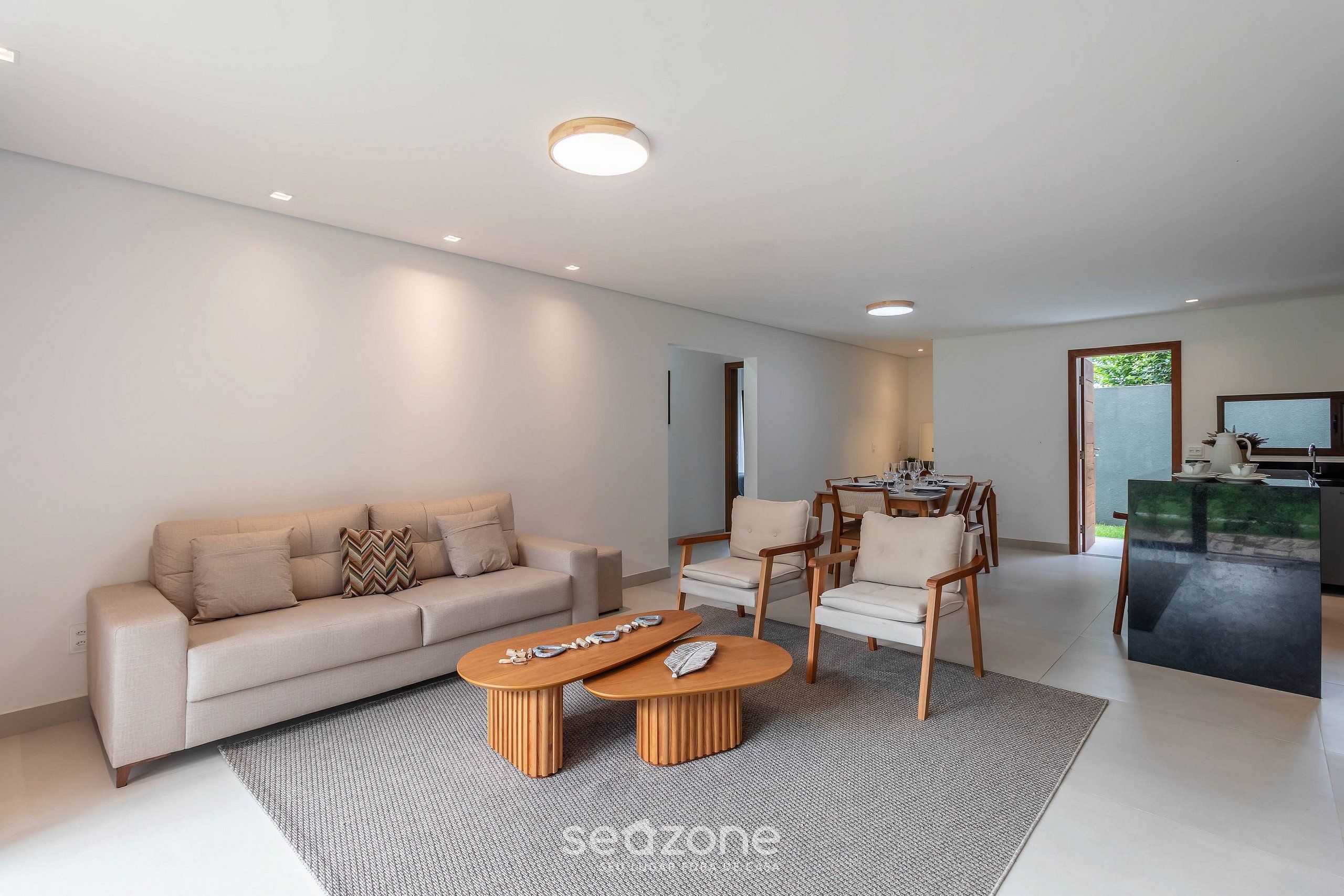 Uma sala moderna com sofá, mesa de centro e área de jantar.