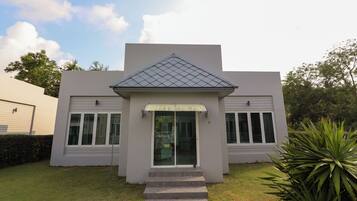 Um edifício moderno com teto plano, entrada coberta e o número '5' na lateral.