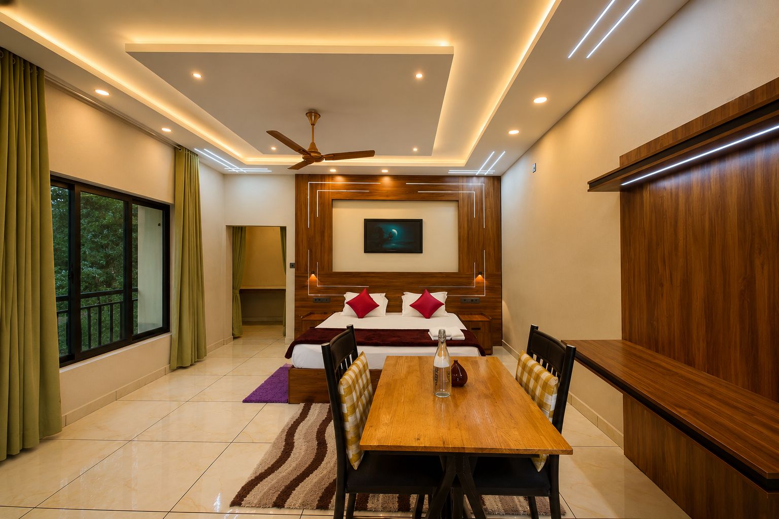 Quarto de hotel moderno com cama, mesa de jantar, cadeiras, ventilador de teto e televisão na parede.