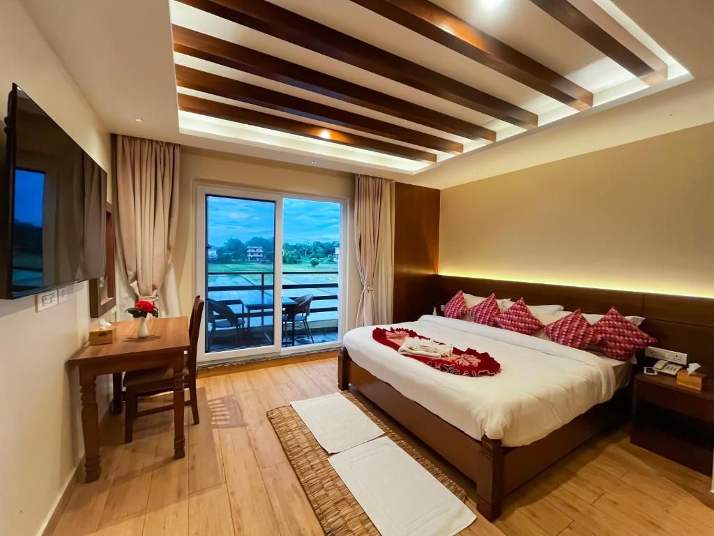 Quarto de hotel com cama, escrivaninha e vista para o exterior.