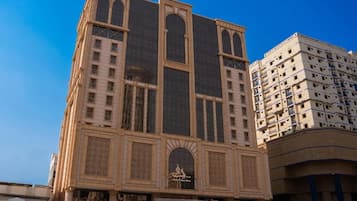Um edifício de vários andares com uma entrada em arco imponente e fachada decorativa.