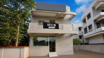 Um edifício moderno de hotel com uma placa que diz 'HOTELO' e 'OYO-SERVICED'.