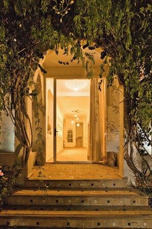 Entrada de um edifício com uma galeria coberta que dá acesso ao interior.