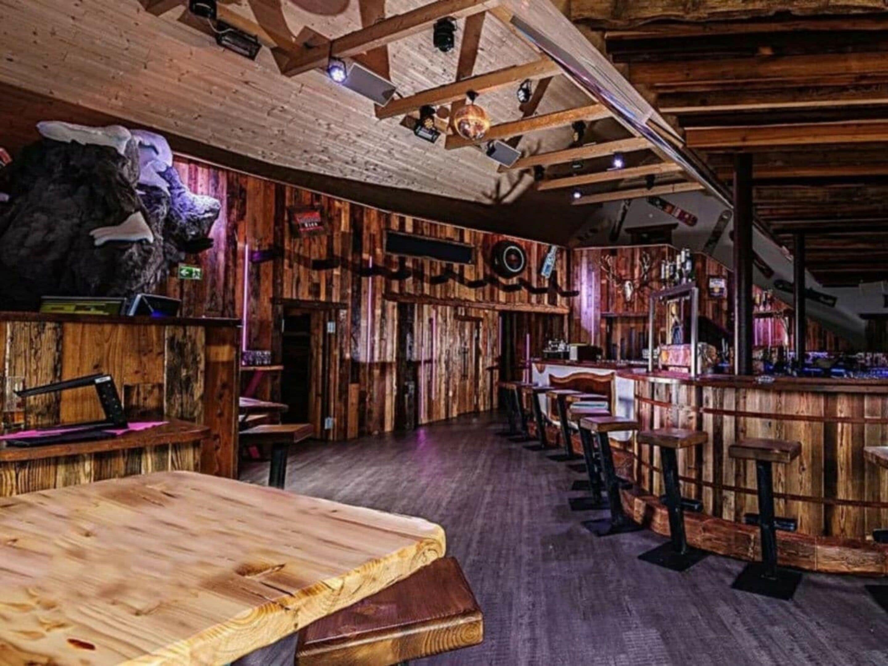 Um interior rústico com paredes de madeira e um espaço de bar.