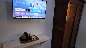 Televisão de tela plana fixada na parede exibindo a interface de um serviço de streaming.
