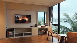 Uma sala de estar moderna com televisão de tela plana, uma mesa de centro e um espaço de refeições com cadeiras.