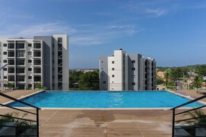 Piscina com vista para edifícios modernos ao fundo.