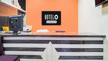 Balcão de recepção de hotel com uma placa que diz 'HOTELO Company Serviced'.