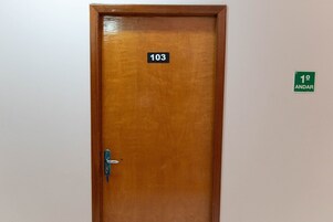 Uma porta de madeira com placa de identificação '103' e fechadura.