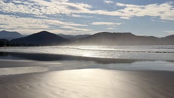 Uma praia com céu claro e sol brilhando.