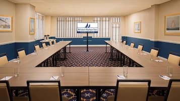 Uma sala de conferências no Bristol Harbor Inn com uma mesa comprida, cadeiras e uma placa indicando sua localização em Rhode Island.
