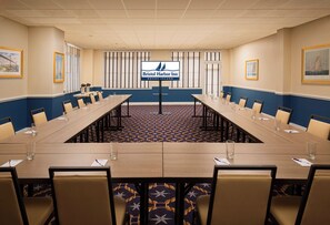 Uma sala de conferências no Bristol Harbor Inn com uma mesa comprida, cadeiras e uma placa indicando sua localização em Rhode Island.