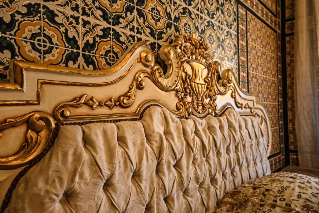 Quarto com parede estampada, cabeceira acolchoada e moldura decorativa.