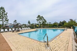 Piscina com espreguiçadeiras e posto de salva-vidas.