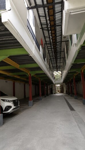 Um parque de estacionamento com vários níveis, com pisos de concreto e vigas de metal.