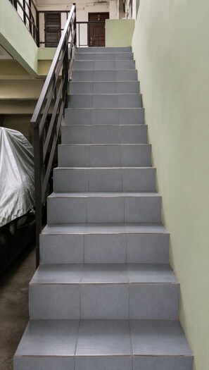 Escadaria com corrimão de metal que dá acesso a um andar superior.