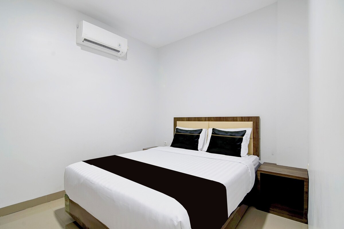Quarto de hotel com cama, mesa de cabeceira e ar condicionado.