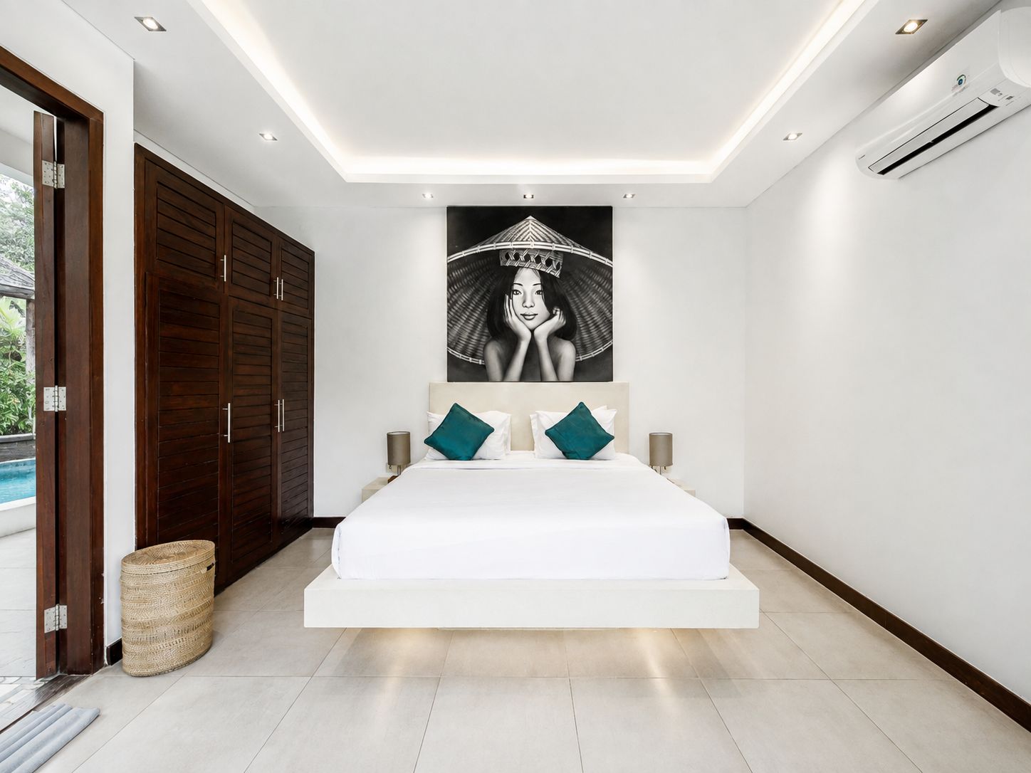 Um quarto moderno com uma cama, uma grande obra de arte na parede e um ar condicionado no teto.