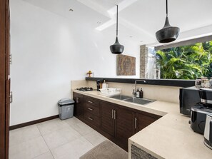 Uma cozinha moderna com armários de madeira escura, uma pia dupla e fogão a gás.
