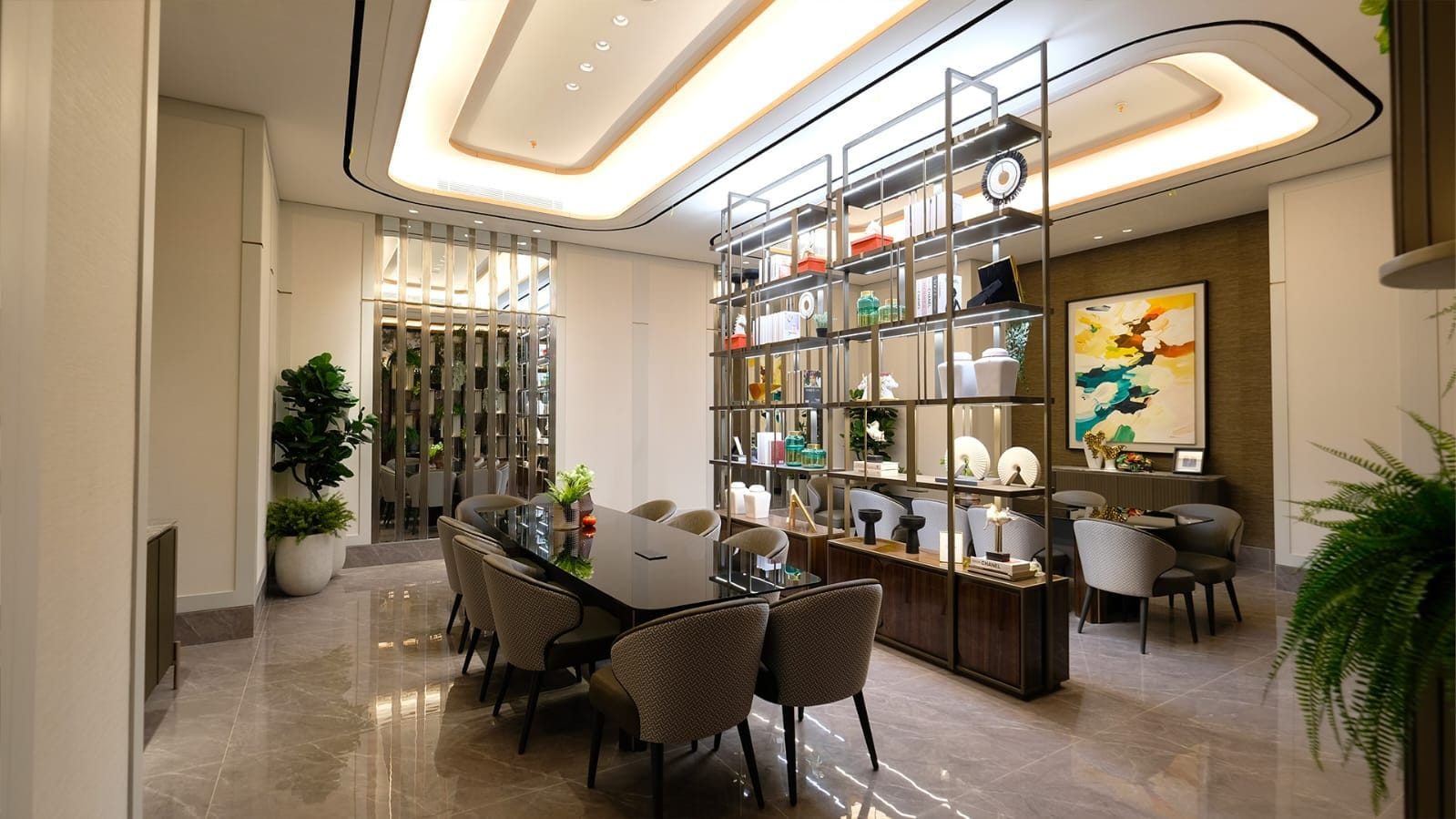 Uma sala de jantar moderna com uma mesa comprida, cadeiras e uma estante decorativa.