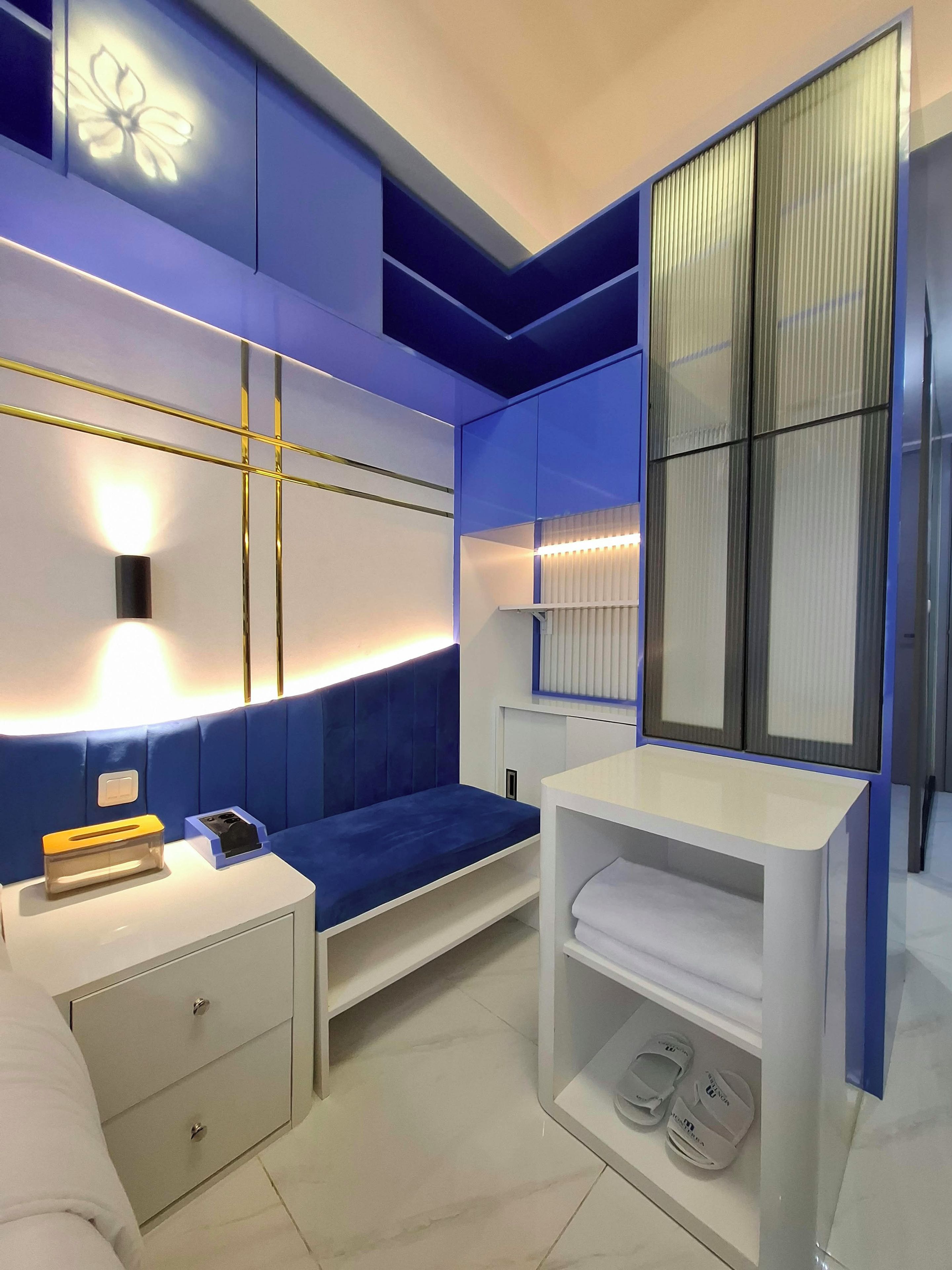 Quarto moderno com cama, mesa de cabeceira e armário embutido.