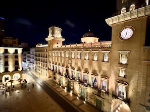 Um edifício histórico com uma torre do relógio e várias janelas.