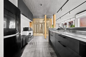 Cozinha moderna com ilha central, eletrodomésticos de aço inoxidável e vista para o exterior.