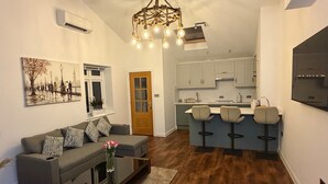 Sala de estar moderna com sofá cinza, mesa de centro e lustre.