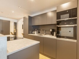 Uma cozinha moderna com eletrodomésticos embutidos, bancada e armários.