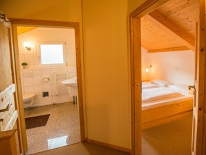 Interior de madeira com banheiro e cama.