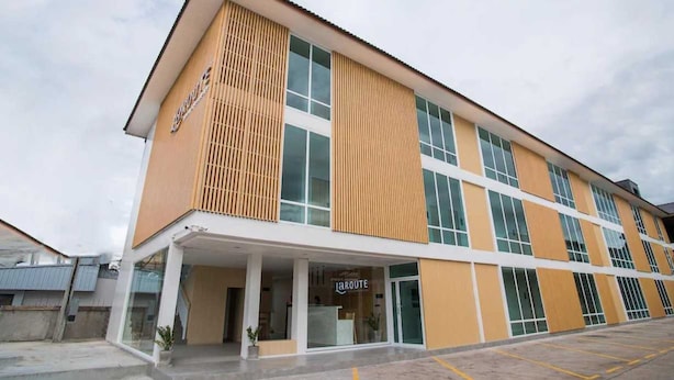 Um hotel moderno com design contemporâneo, teto plano, amplas janelas e área de entrada coberta.