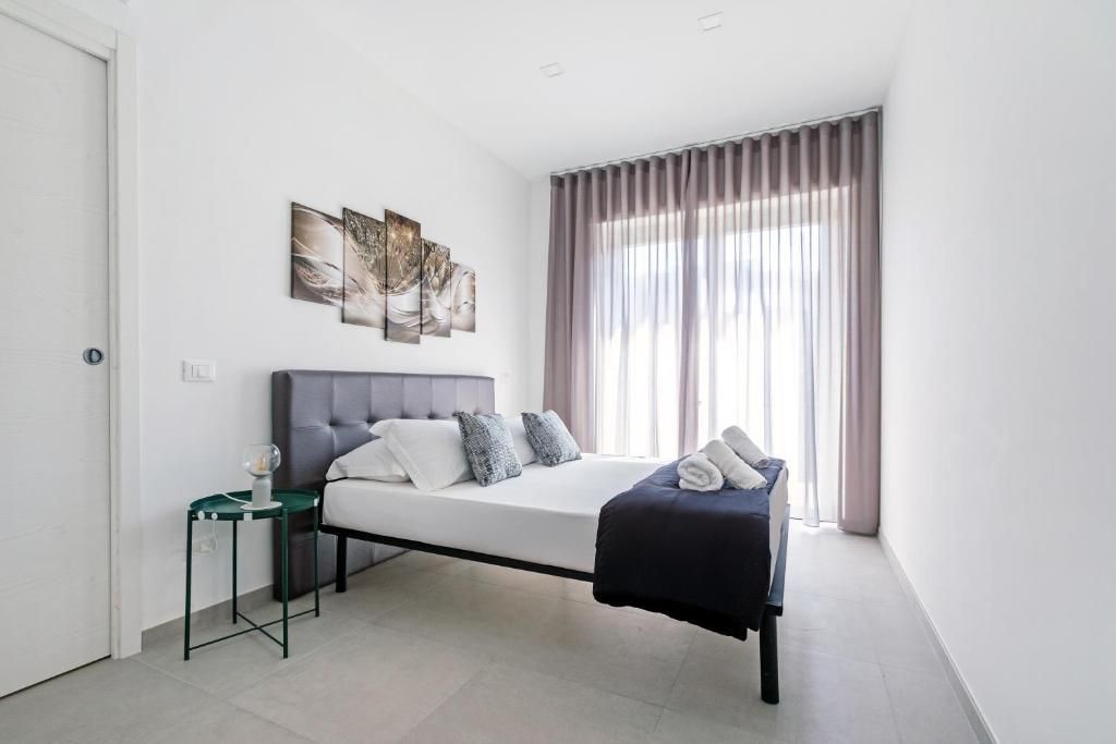 Um quarto moderno com cama, mesa de cabeceira e janela com cortinas.