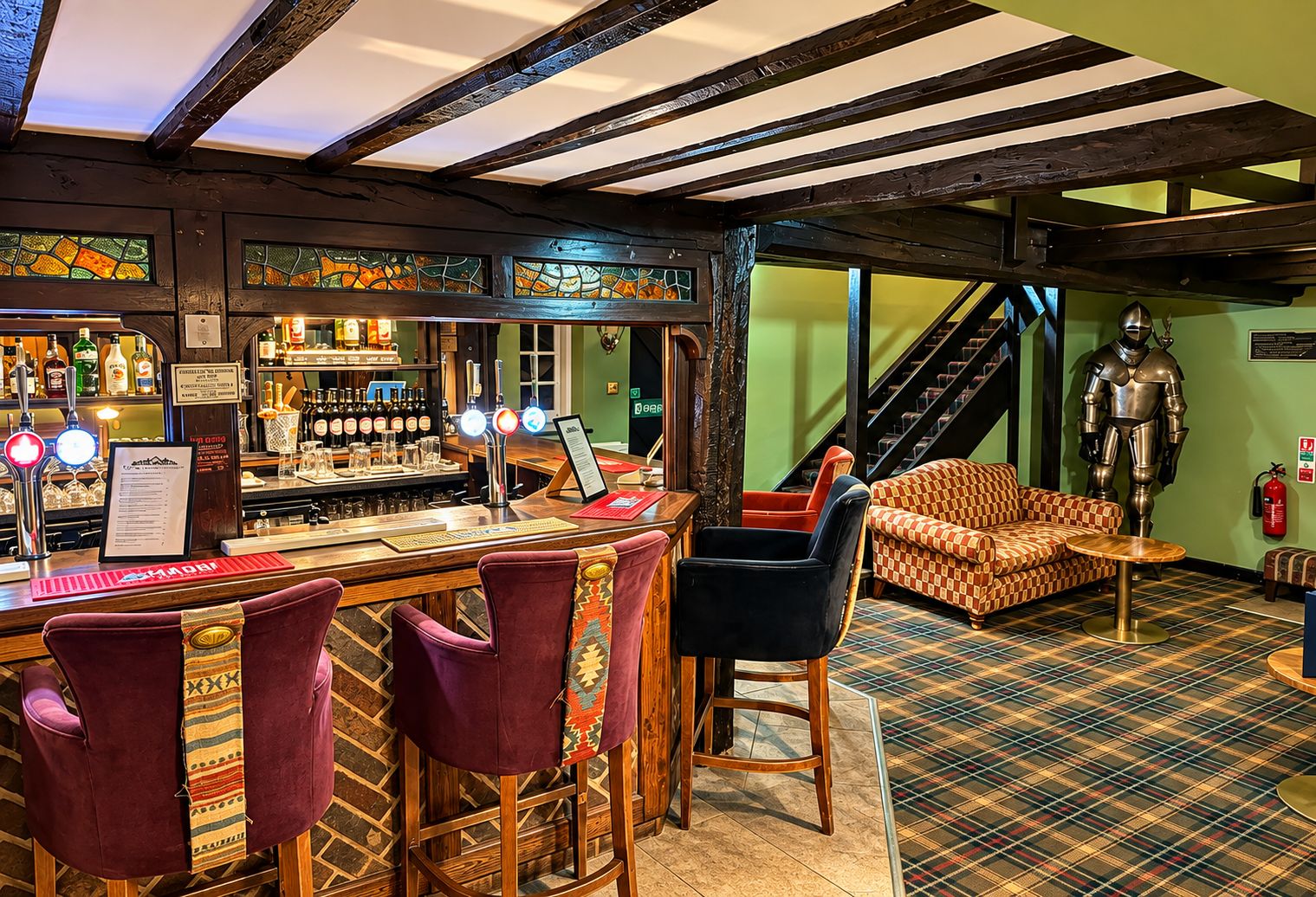 Uma área de bar com banquetas, balcão e escada que leva a um andar superior.