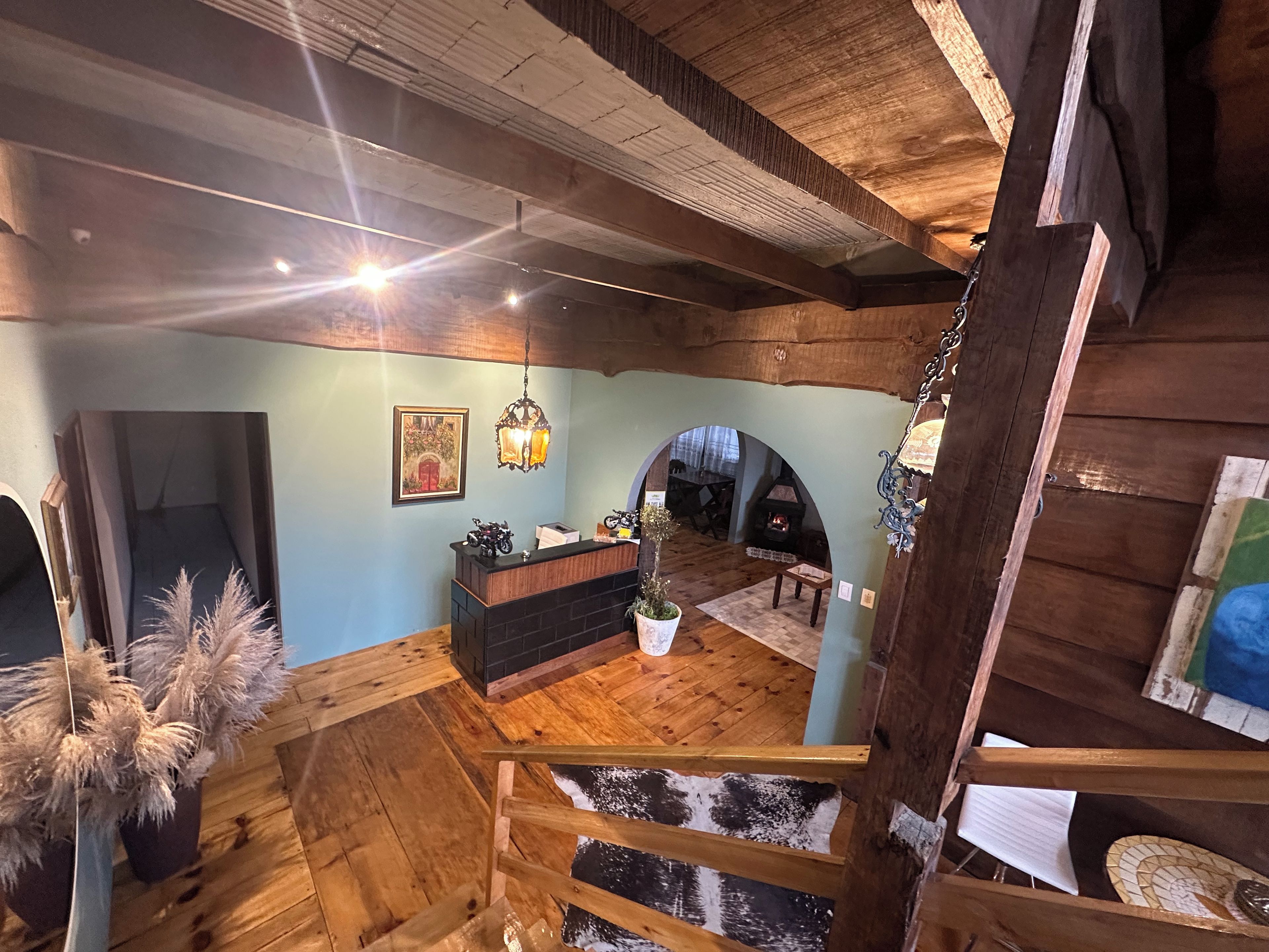 Um interior rústico com escada de madeira, lareira e sala de jantar.