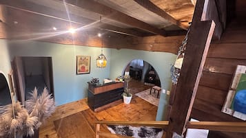 Um interior rústico com escada de madeira, lareira e sala de jantar.
