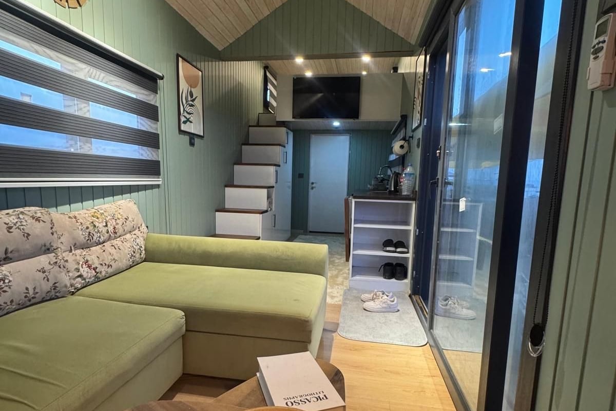 Uma sala de estar aconchegante com um sofá seccional, uma mesa de centro e uma estante de livros.