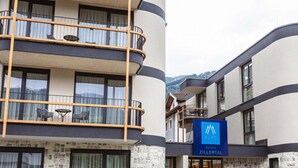 Um hotel com design moderno, com varandas e área de estar externa, e uma placa com o nome 'Zillertal'.