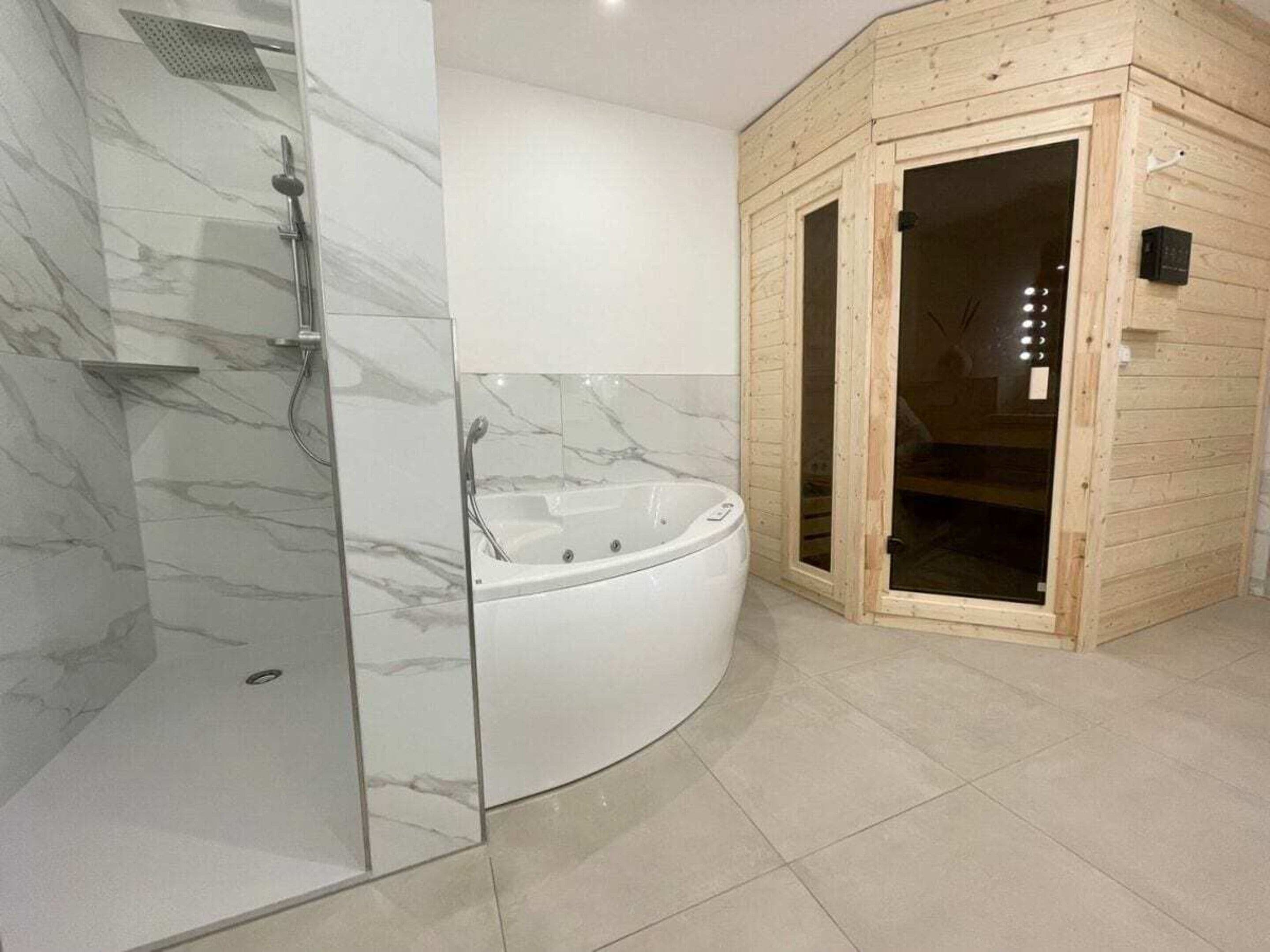 Um banheiro moderno com chuveiro envidraçado, banheira independente e sauna de madeira.