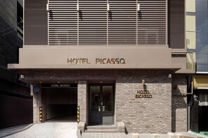 Um edifício com uma placa indicando 'HOTEL PICASSO' na entrada.