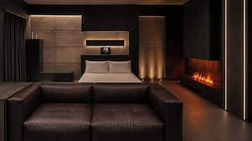 Quarto moderno com sofá, cama e lareira.