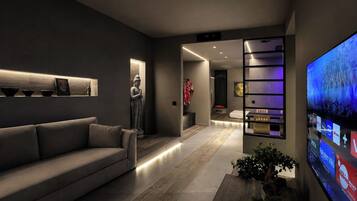 Uma sala de estar moderna com sofá, estátua de Buda, televisão e piso de madeira.