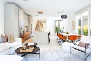 Um interior moderno com área de jantar, cozinha e sala de estar.