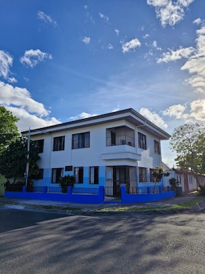 Um edifício de dois andares com telhado plano e fachada azul e branca.