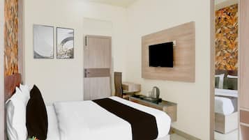 Quarto de hotel com cama, escrivaninha, televisão e obras de arte nas paredes.