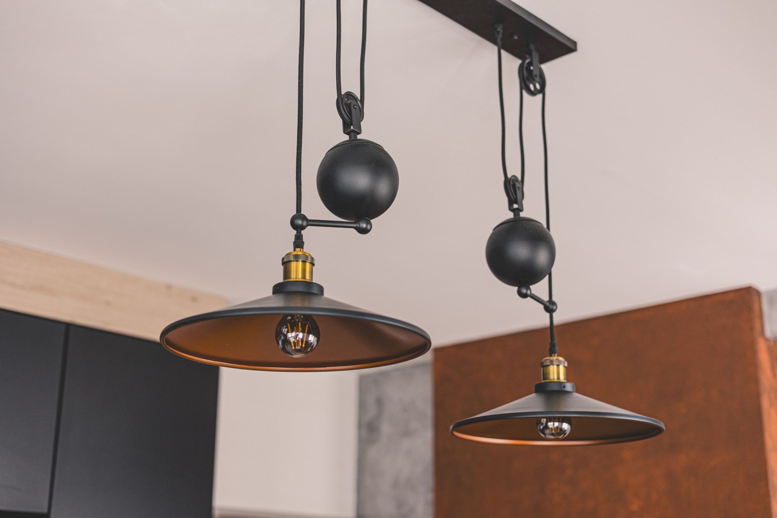 Duas luminárias pendentes com lâmpadas aparentes suspensas no teto.