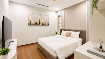 Um quarto moderno com cama, mesa de cabeceira, televisão e obras de arte.