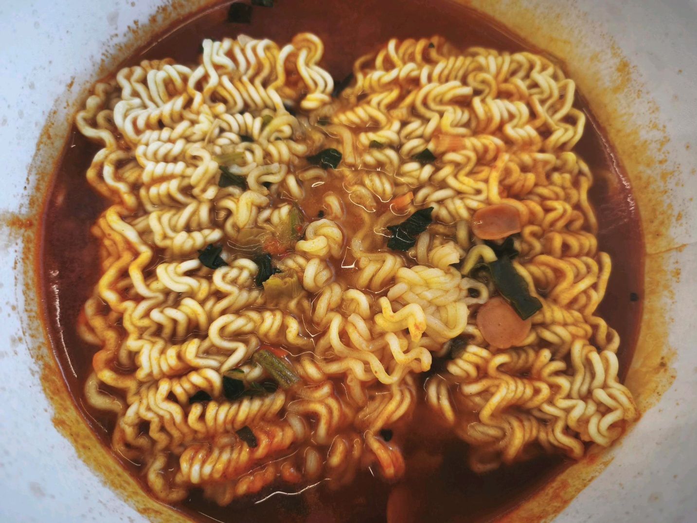 Uma tigela de ramen com macarrão, caldo e vegetais.