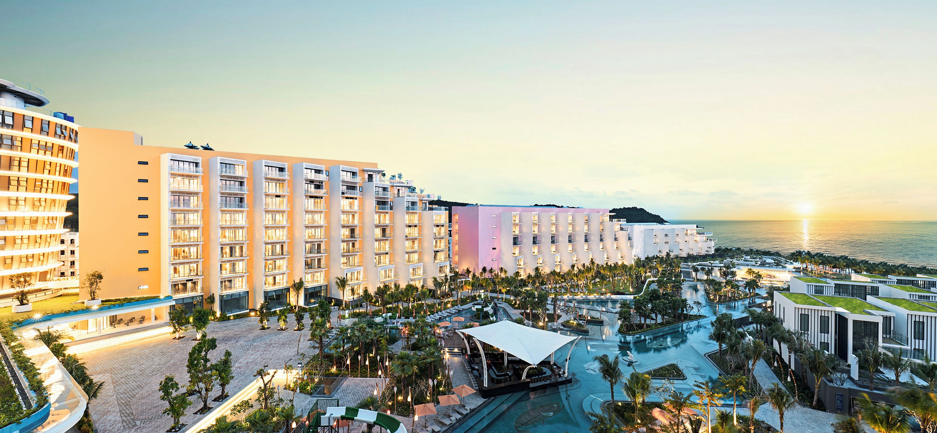 Resort com vários edifícios, área de piscina e vista para o oceano.
