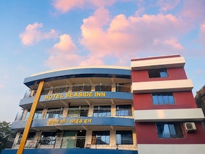 Um hotel com vários andares, fachada curva e varandas.