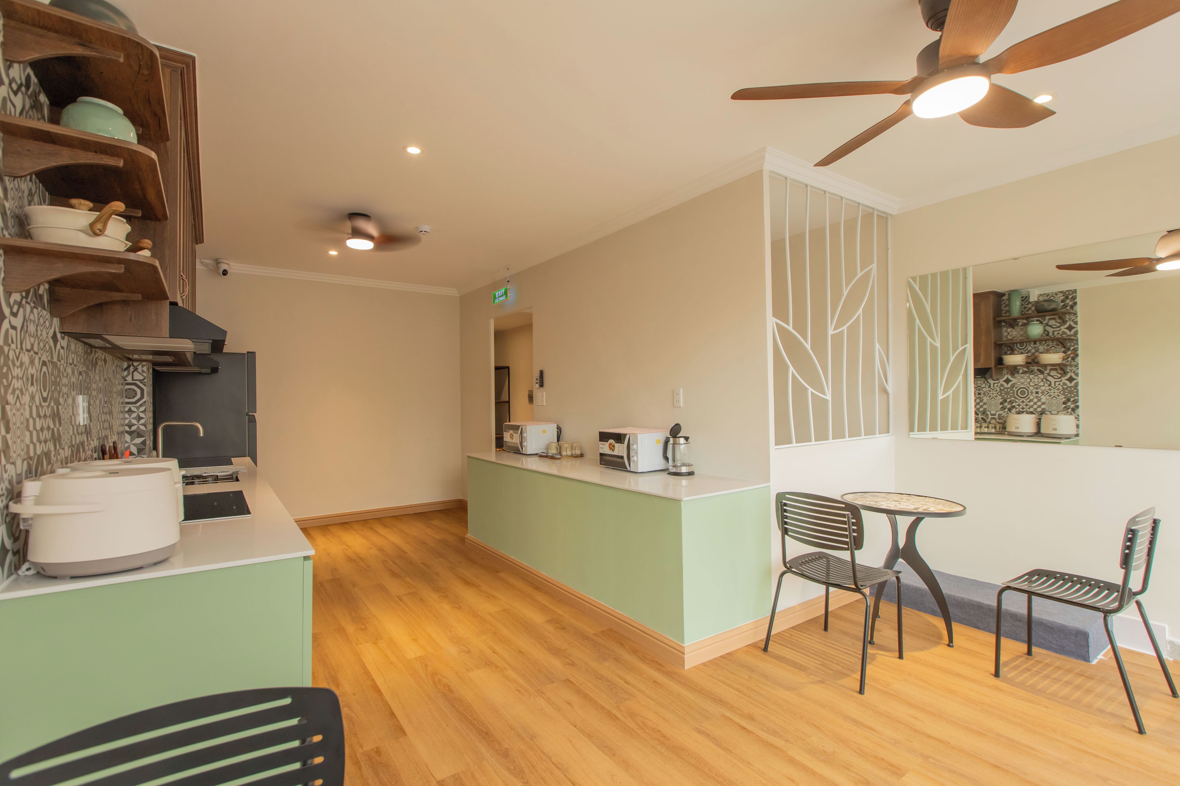 Cozinha moderna com área de refeições, piso de madeira e ventilador de teto.